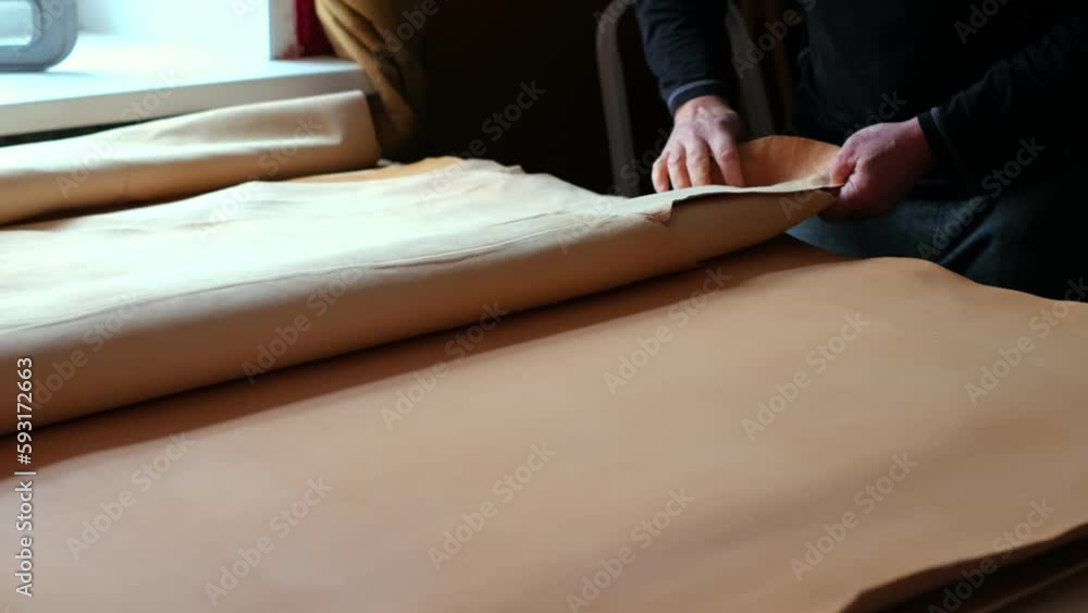 elderly leather craftsman proudly displays his collection of high ...