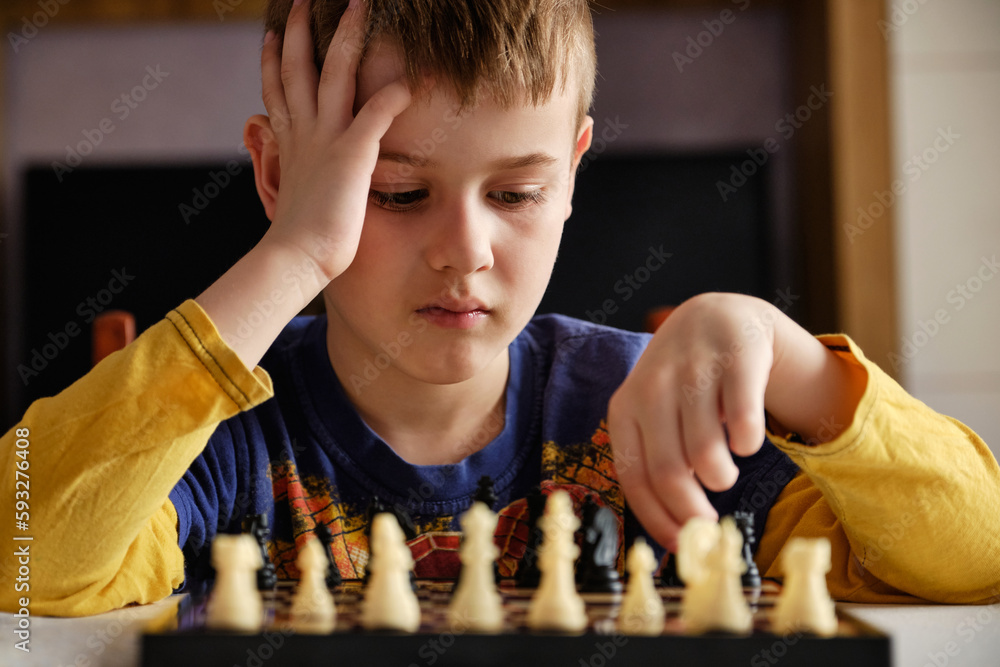 Cute little boy plays chess. Education concept, intellectual game ...