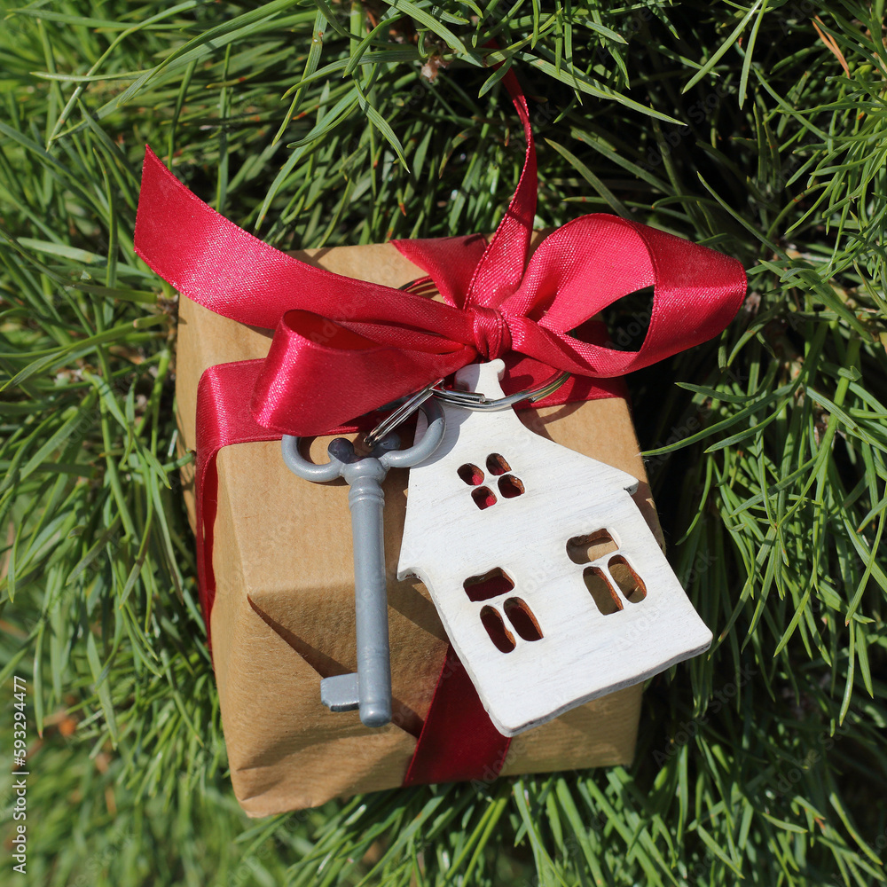 key and the layout of the house are tied to a gift with a red bow on ...