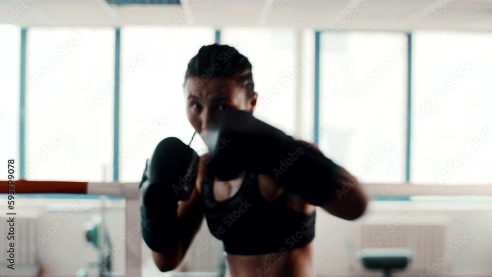 Asian woman boxer with boxing glove on hands trains punches in gym ...
