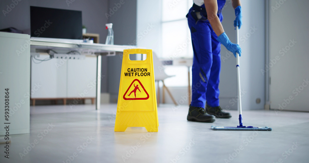 Male Janitor Cleaning Floor With Caution Wet Floor Sign Stock Photo ...