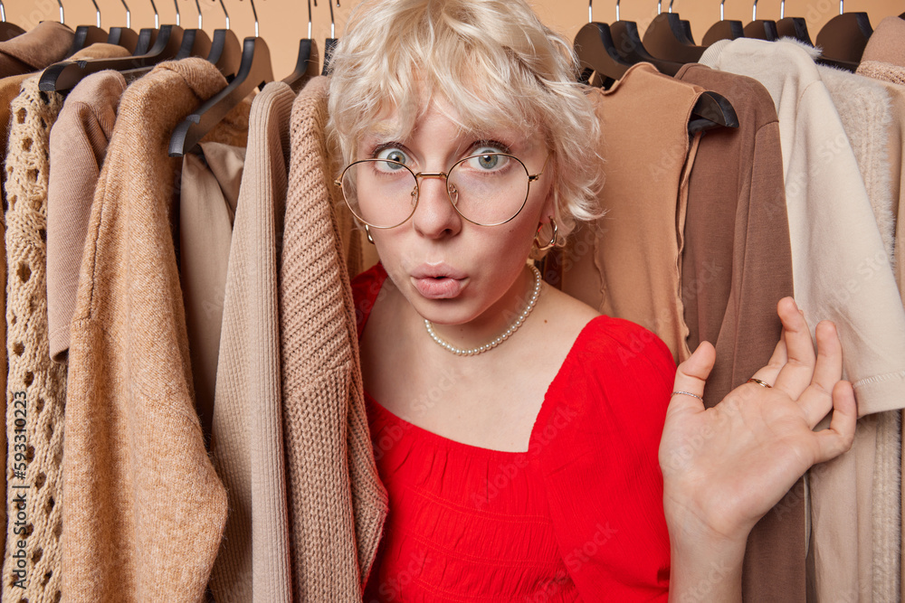 Stupefied blonde adult woman wears round spectacles necklace and red ...