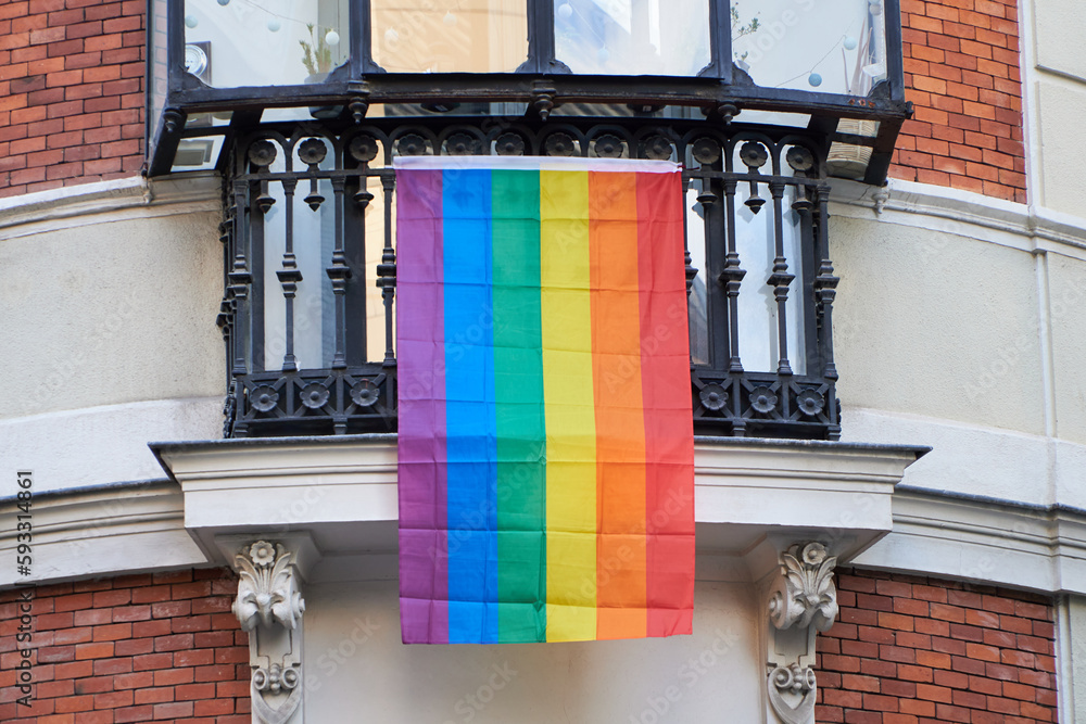 lgbt flag hanging on a balcony of classic building. LGBTQ+ pride ...