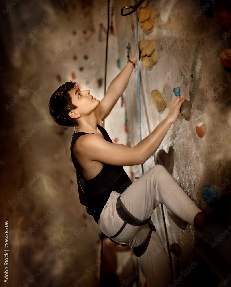 Positive extreme young guy with rope training on concrete climbing rock ...