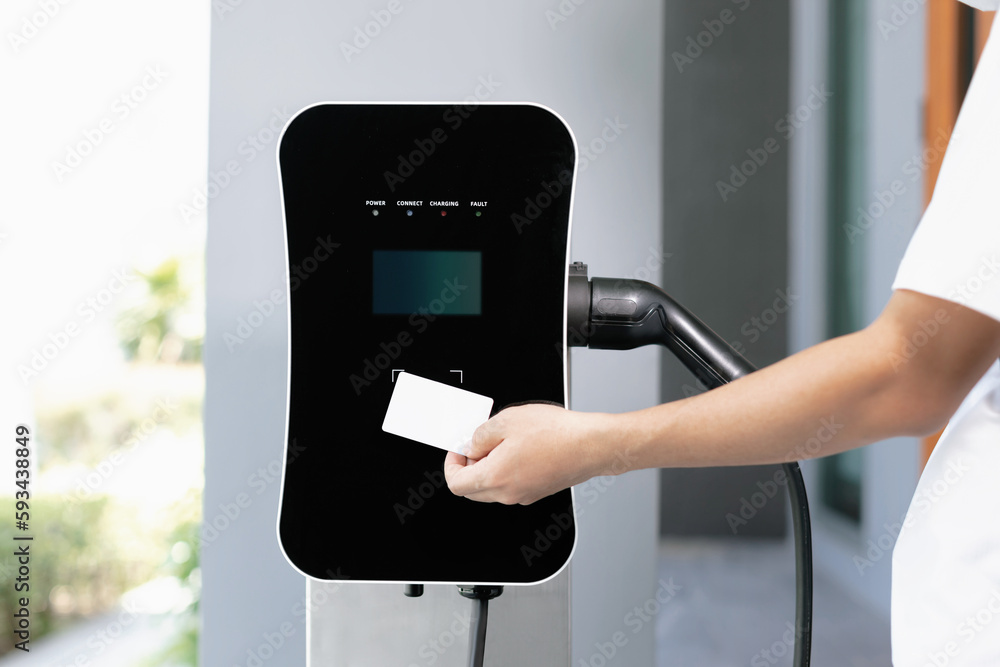 Hand holding credit card to pay public charging station and recharge ...