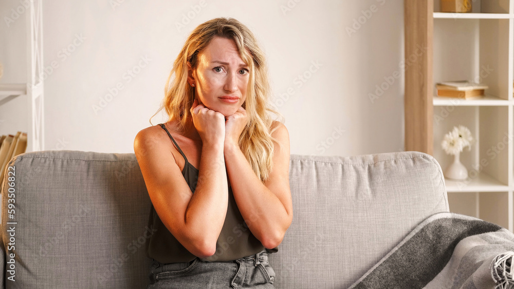 Shocked situation. Scared woman. Fear frustration. Disbelief lady being worried sitting sofa in ...