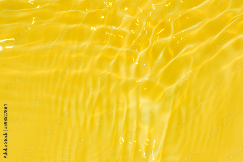 Defocus blurred transparent yellow colored clear calm water surface ...