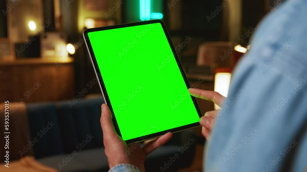 In the evening hands holding scrolling tablet computer with a vertical ...