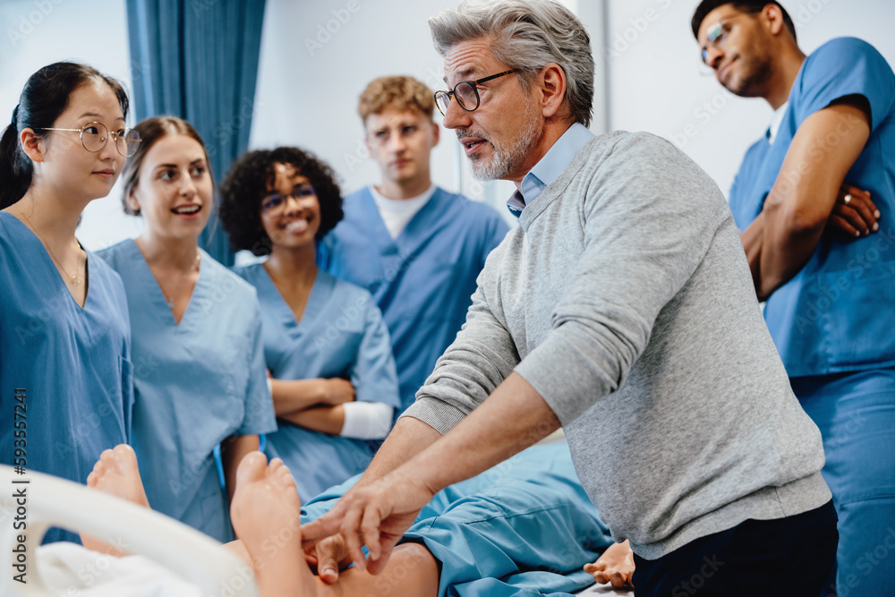 Doctor training a group of medical students using a patient simulator ...