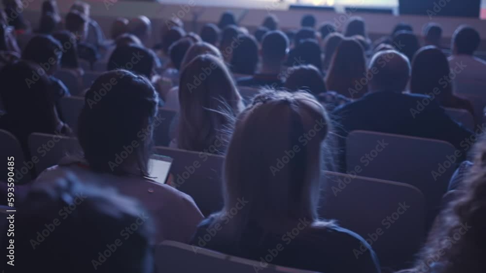 Business People Sitting in Audience Using Mobile Phone and Looking at ...