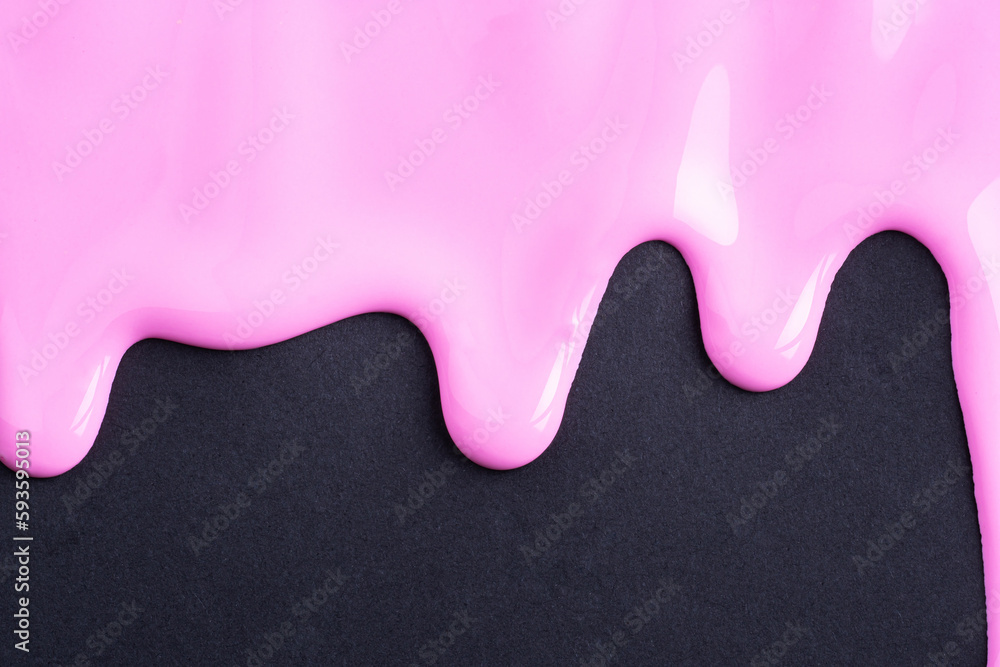 Pink liquid drops of paint color flow down on black paper. Abstract art ...