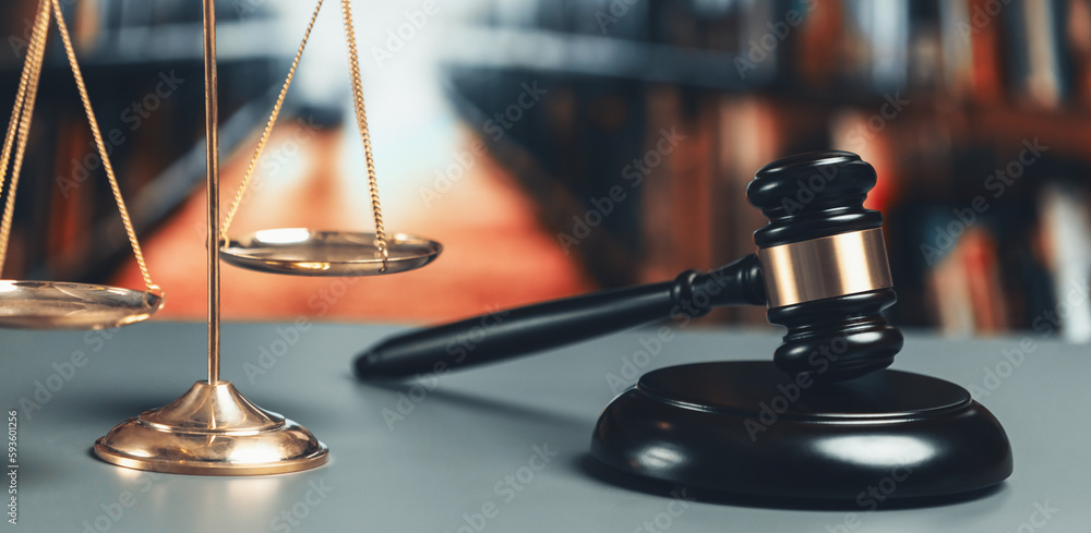 Shiny golden balanced scale and wooden gavel in court library ...