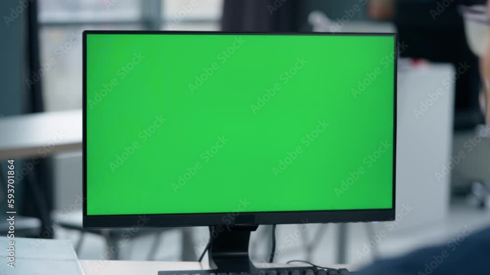 oung Man Working At Computer With Green Mock Up Screen in Office. Close Up Desktop Computer ...