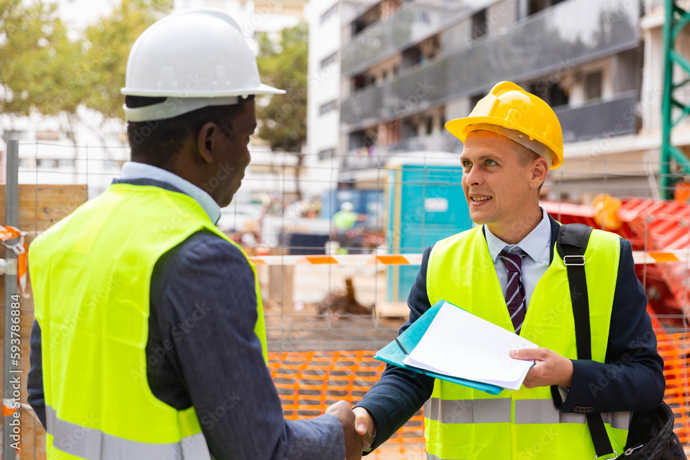 Architect and engineer construction workers shaking hands while working ...
