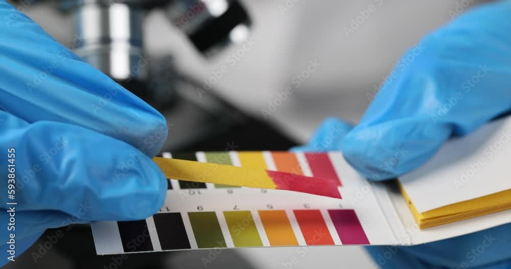 Vídeo do Stock: Hand is holding pH indicator and comparing color with ...
