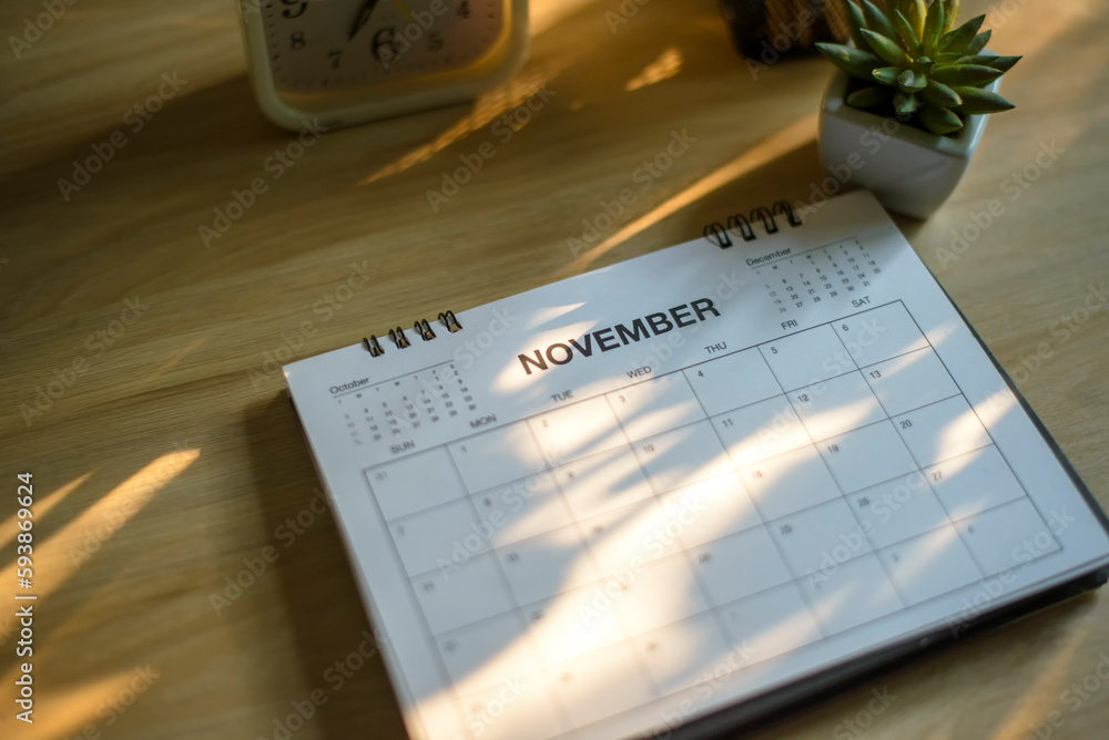Desktop calendar, clock, and cactus placed on student wooden desk ...