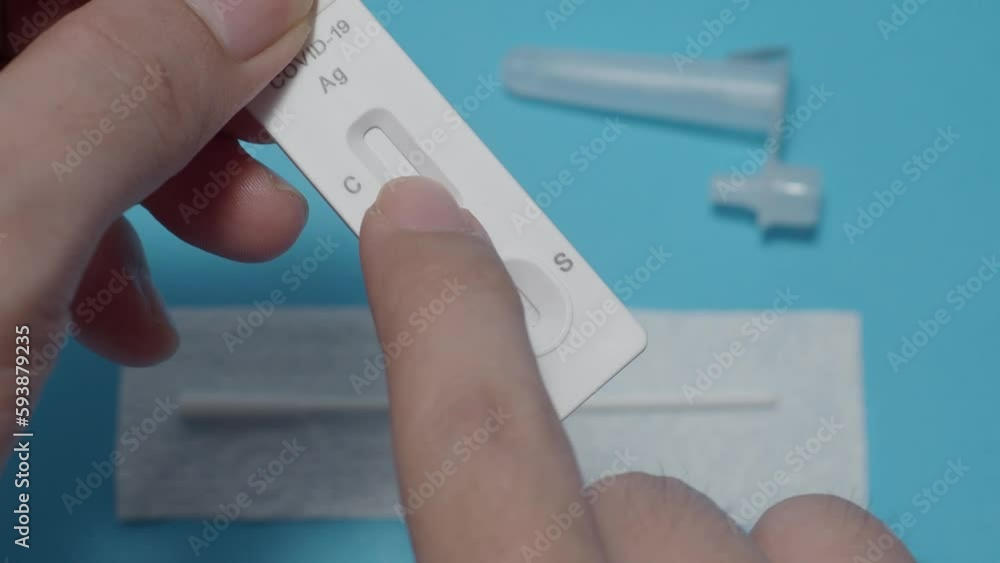 POV of Man hands using Rapid antigen test kit or ATK and blue ...