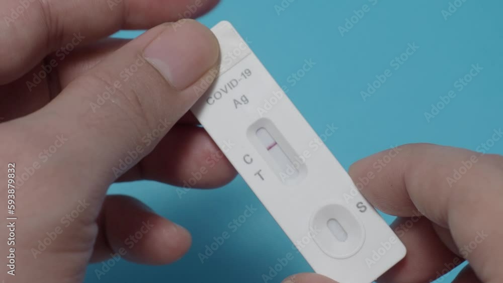 POV of Man hands using Rapid antigen test kit or ATK and blue ...