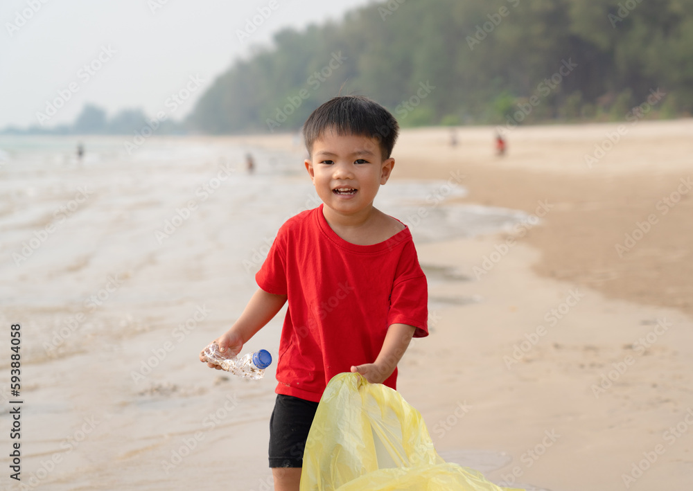 happy little boy picking up trash drinking water bottle into garbage ...