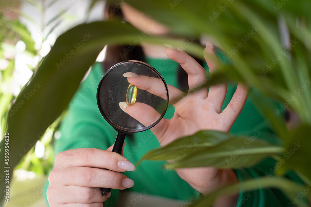 scientist with a magnifying glass checks defective medical pills ...
