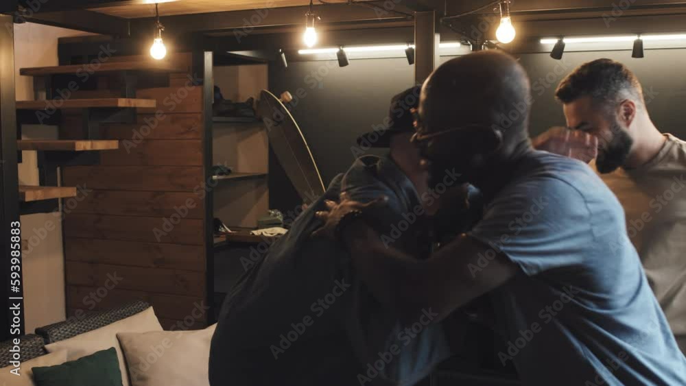 Lateral medium shot of two friends, African American man and Caucasian ...