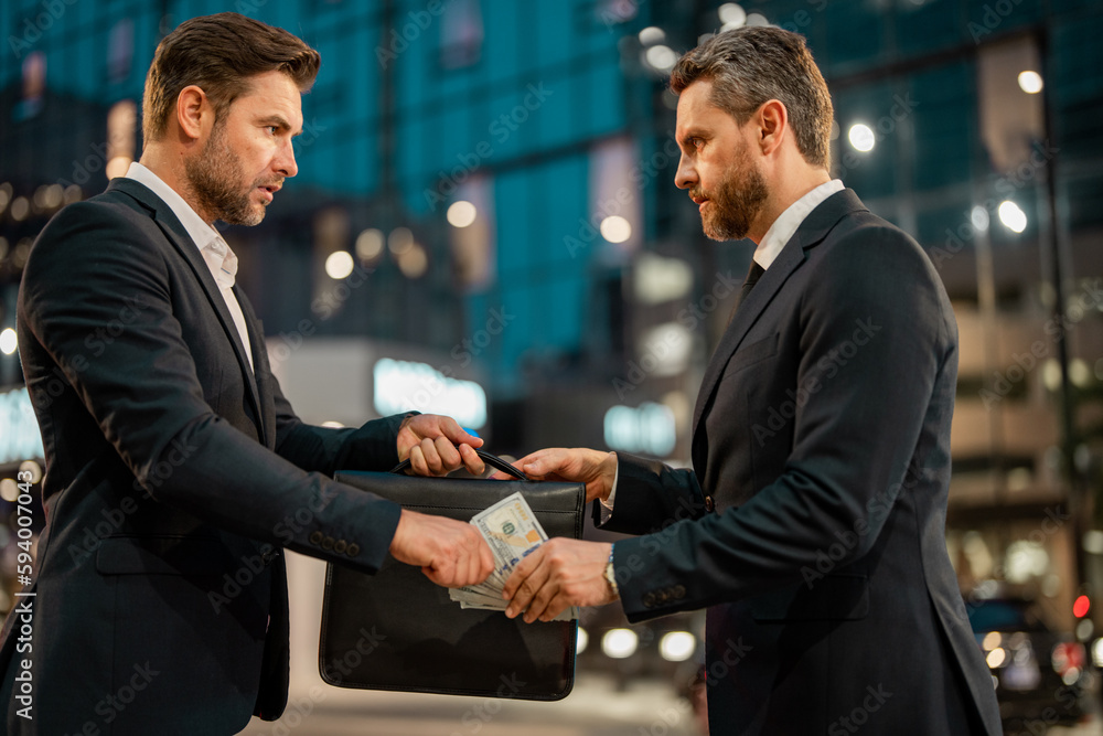 Businessman giving money to his partner while making contract ...
