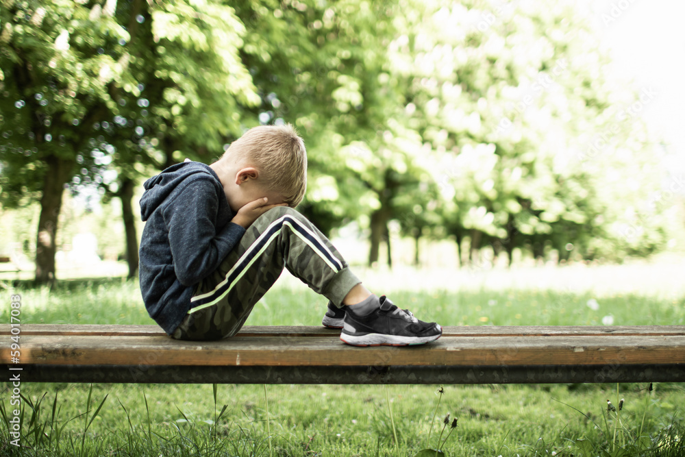 Sad lonely child crying on park bench Stock Photo | Adobe Stock