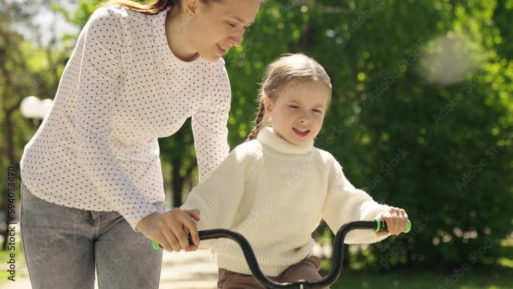 Video Stock faces of happy child girl daughter learns ride bike. Mom ...