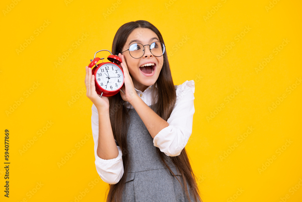 Teen student girl hold clock isolated on yellow background. Time to ...