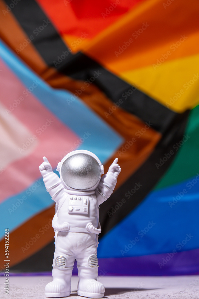 Toy astronaut on Rainbow LGBTQIA flag made from silk material ...