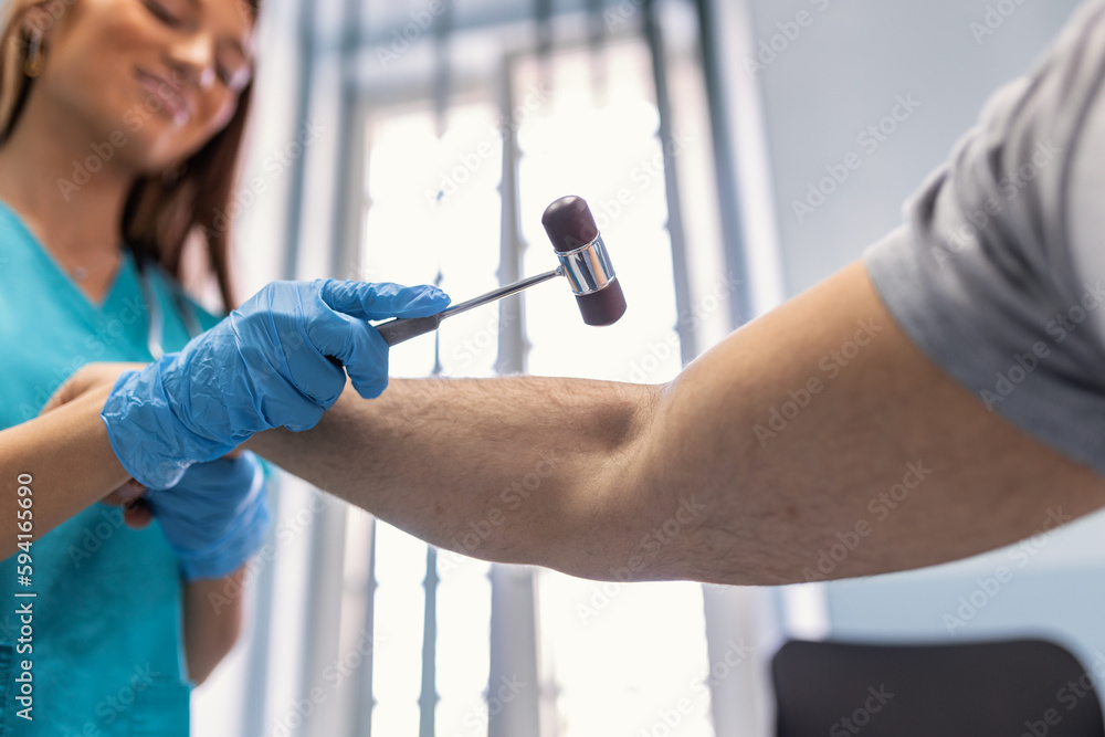 Neurological examination. The neurologist testing reflexes on a male ...