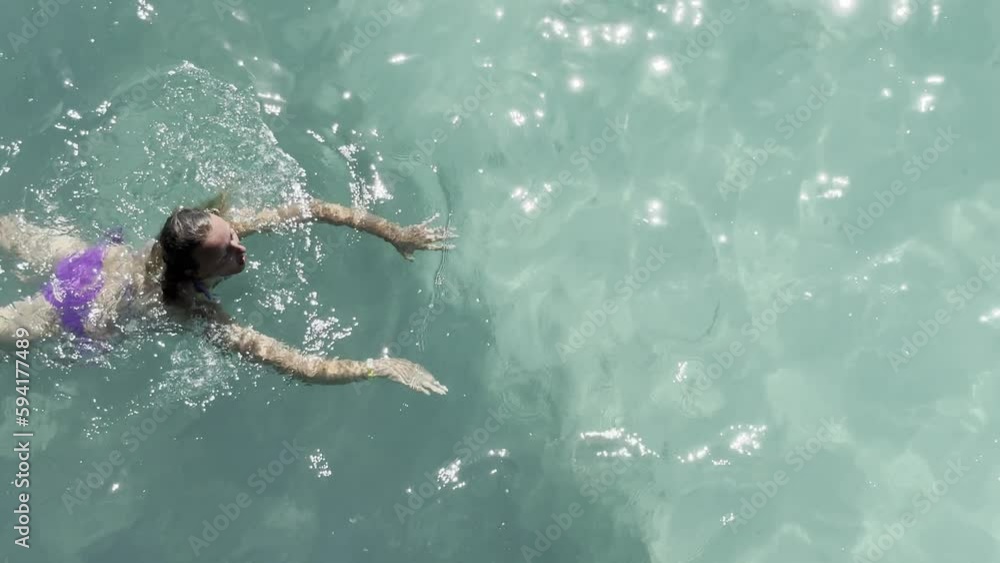 Top view of a woman floating in the sea. Top view of a young girl in a ...