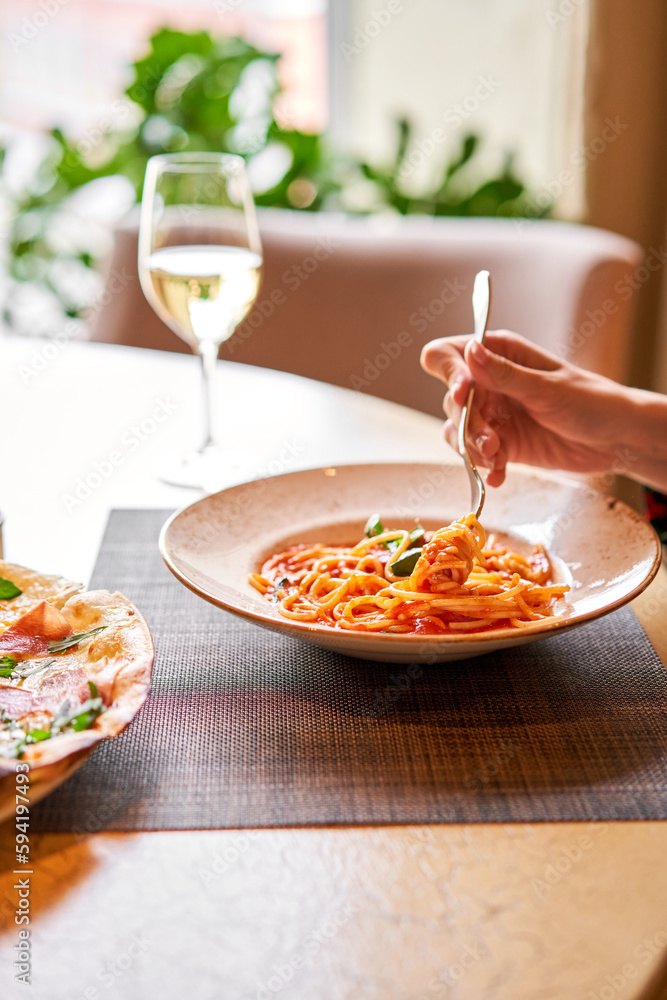 Italian Trattoria. Woman eats Italian pasta with tomato, meat ...