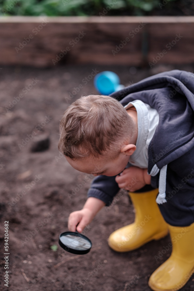 Curious little preschool boy child with magnifying glass searching for ...