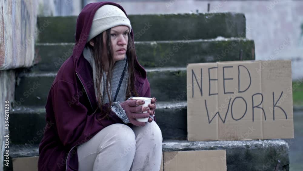 Homeless young woman is poorly dressed, dirty and needs help. Beside ...