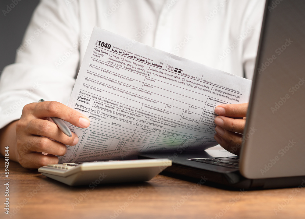 Hand holding of form 1040. U.S. individual income tax return while ...