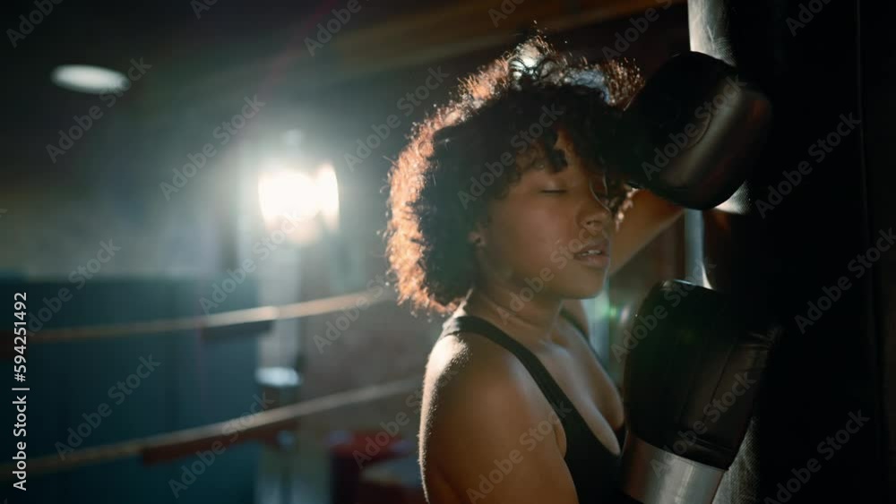African american woman boxer stands near punching bag on boxing ring ...