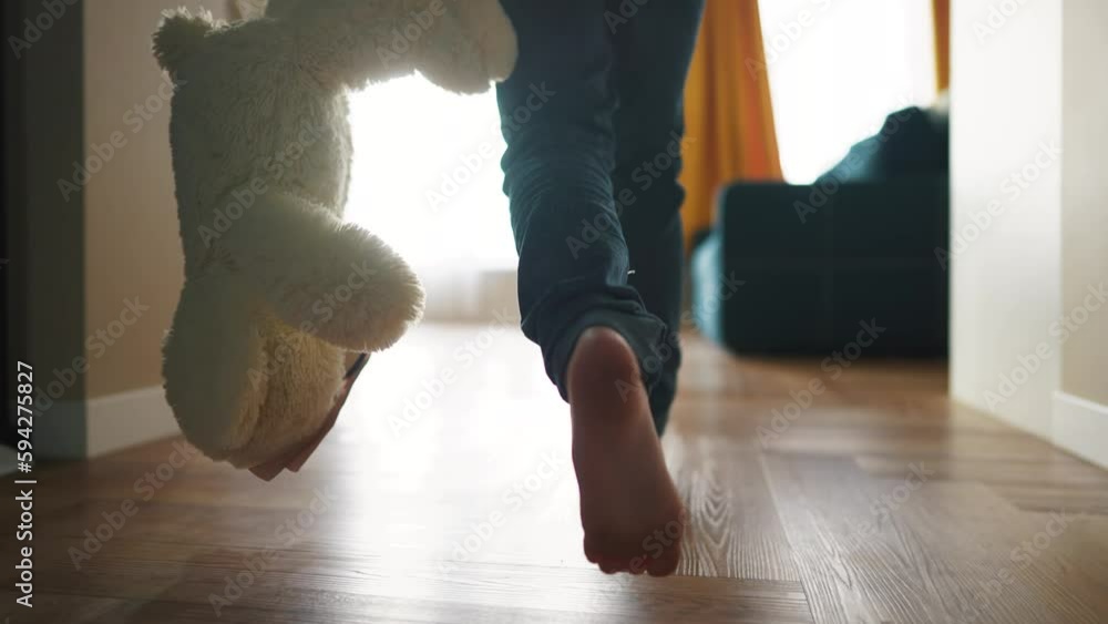 baby running indoors with bare feet. close-up of the kid leg runs with ...