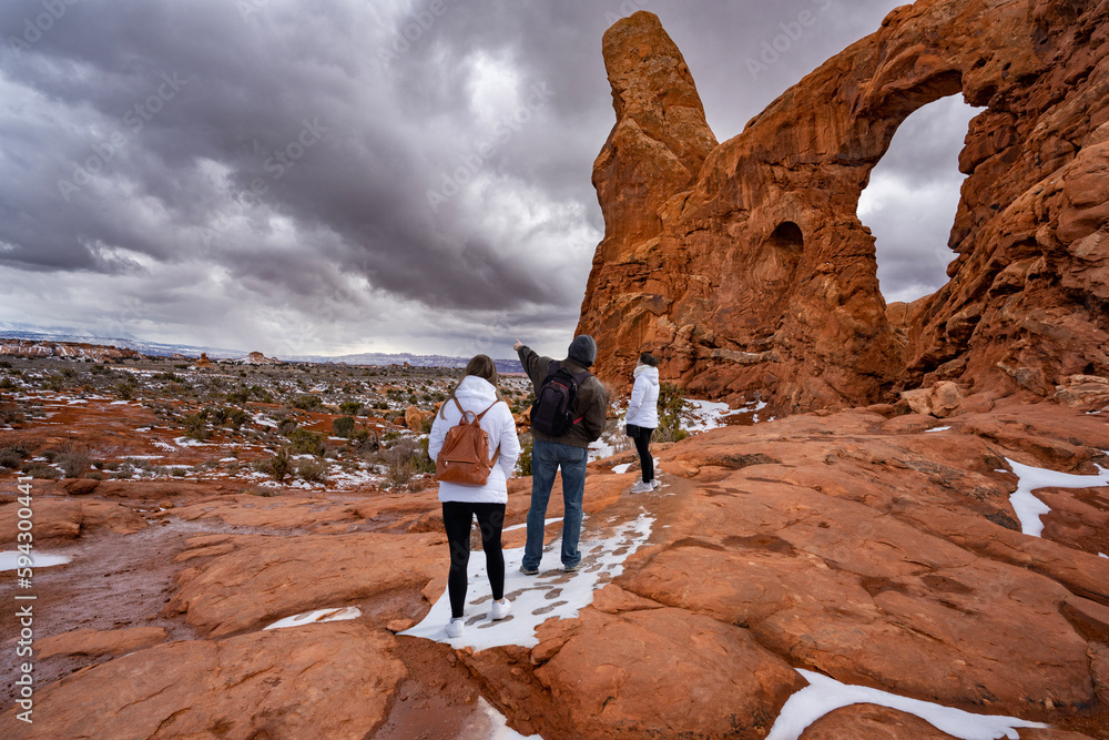Family hiking in red mountains in Utah next to Turret Arch. People ...
