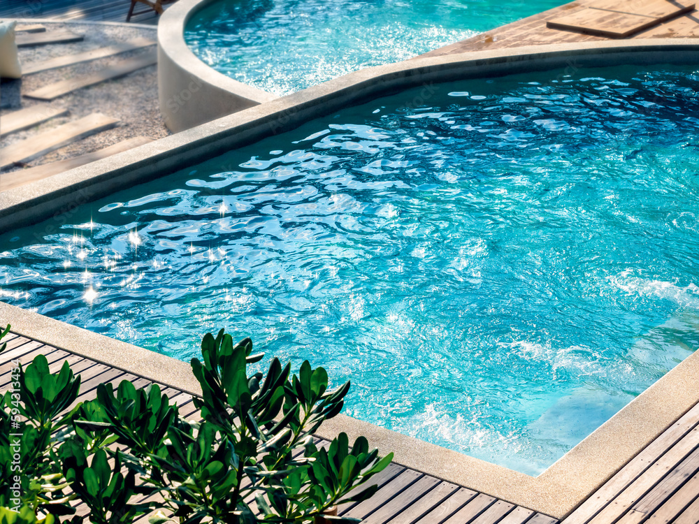 Empty curved swimming pool with clean clear water, nobody. Outdoor pool ...