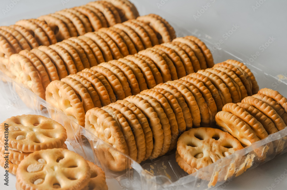 Several round biscuits with peanut butter arranged in a tight row in a ...