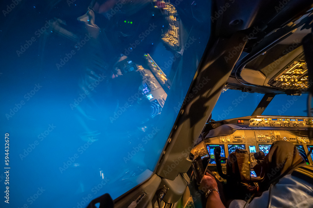 Pilot view of a Boeing 737 cockpit during cruise flight at night. Stock ...