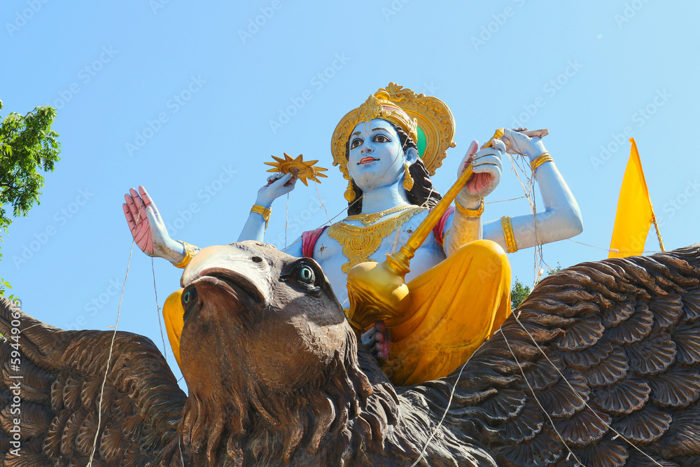 The Supreme God Vishnu with attributes of power in four hands flies ...