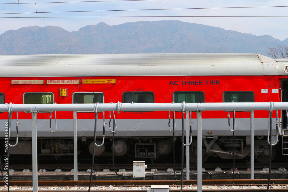 Red train car on the Indian railway against the backdrop of mountains ...