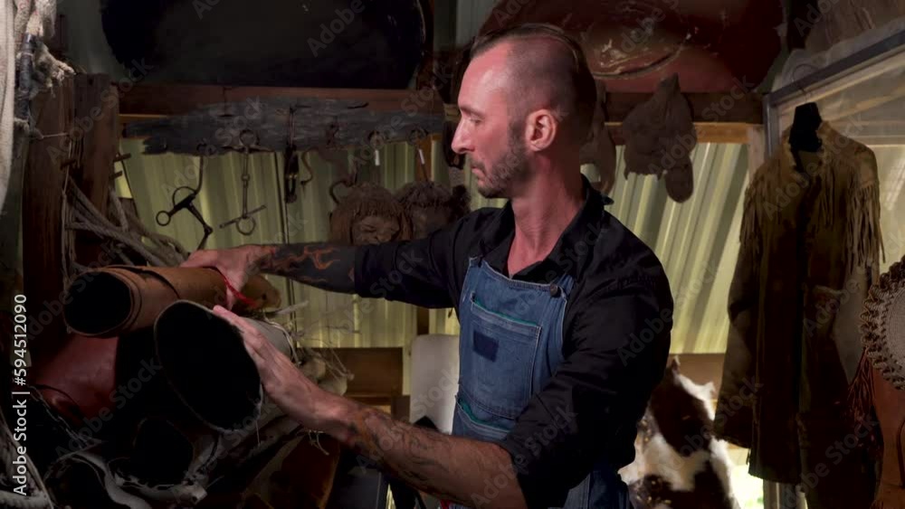 4K, Tall man was handmade by leather craftsman, was standing picking up ...