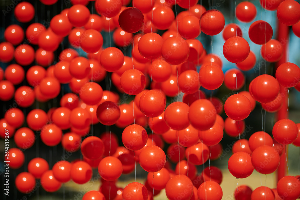 Red balls suspended on wire, outdoor art object symbolizing blood cells ...