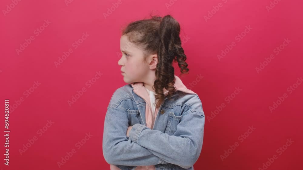 Portrait of sad unhappy little girl kid posing with crossed arms and ...