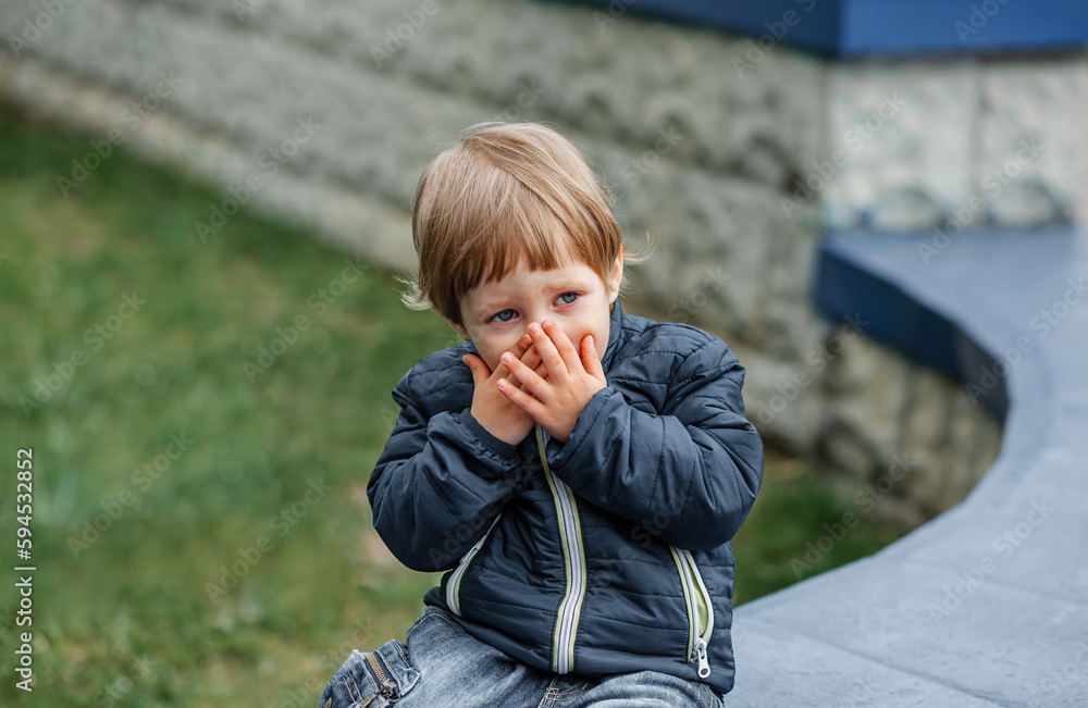 Kid hiding behind palms of his hands. Upset child covering his face at ...