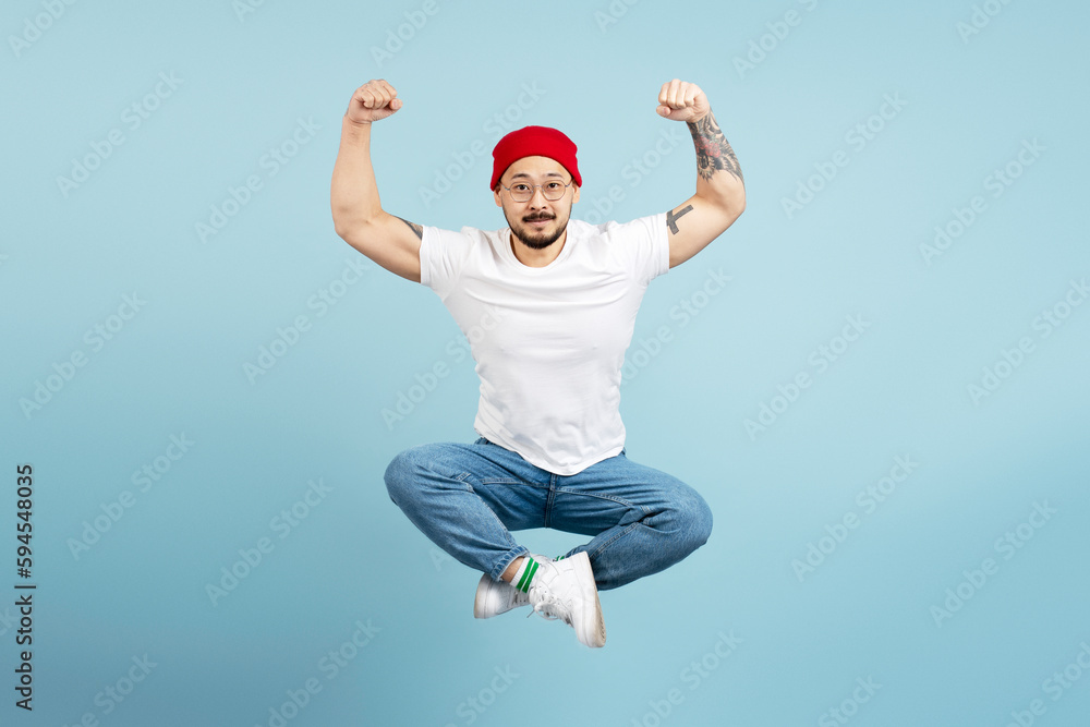 Strong asian man, bodybuilder with stylish tattoo showing muscles ...