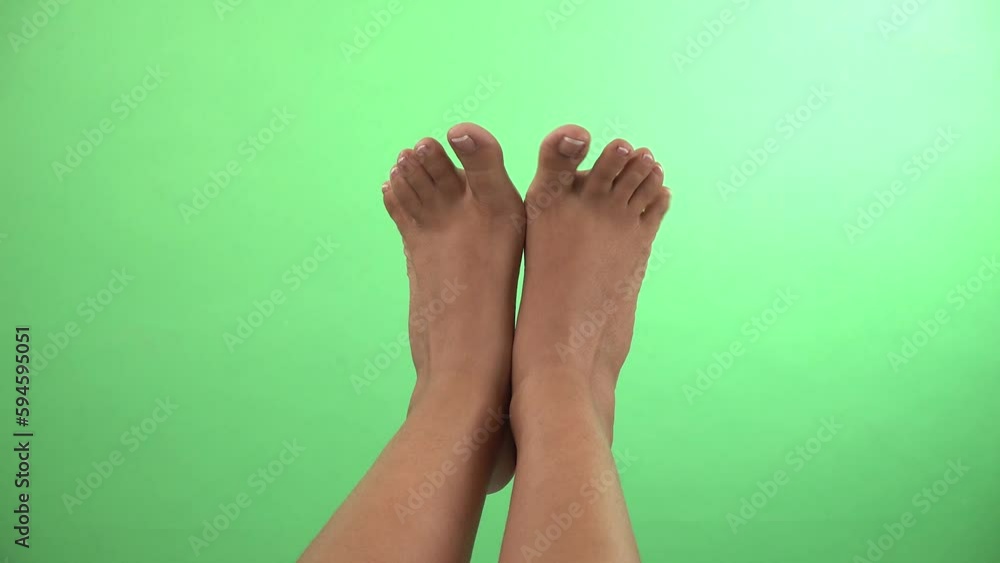 Close-up of a woman's beautiful, perfect feet while wiggling her toes ...